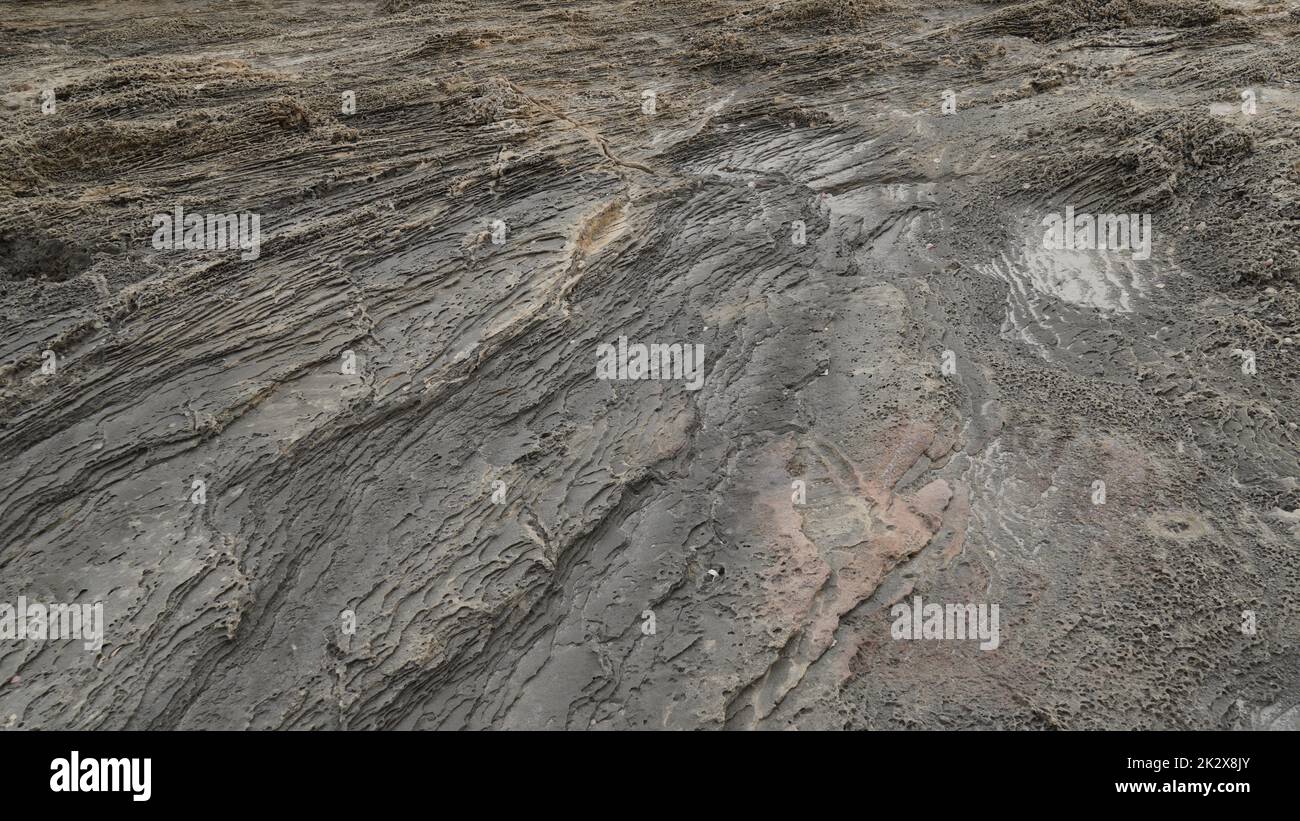 Volcanogenic rock slabs on the seashore. Natural rocky breakwater at ...