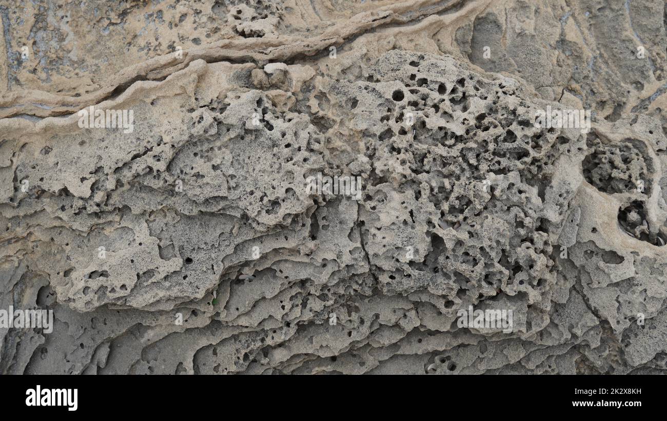 Volcanogenic rock slabs on the seashore. Natural rocky breakwater at ...