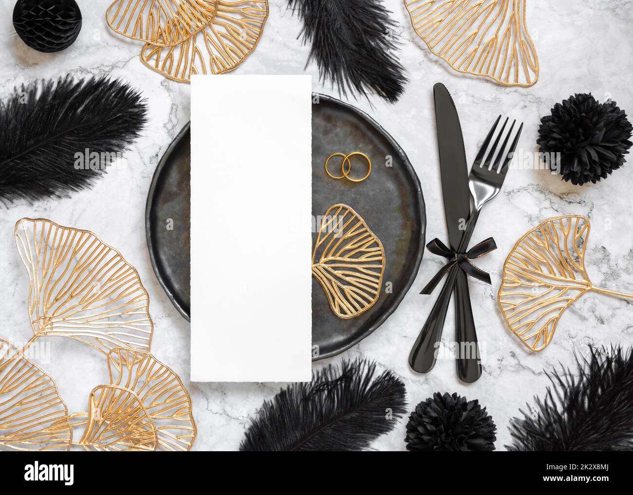 Black and golden wedding table setting with a blank card and rings top ...
