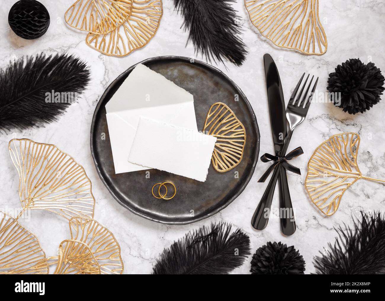 Black and golden wedding table setting with a place card and rings top ...