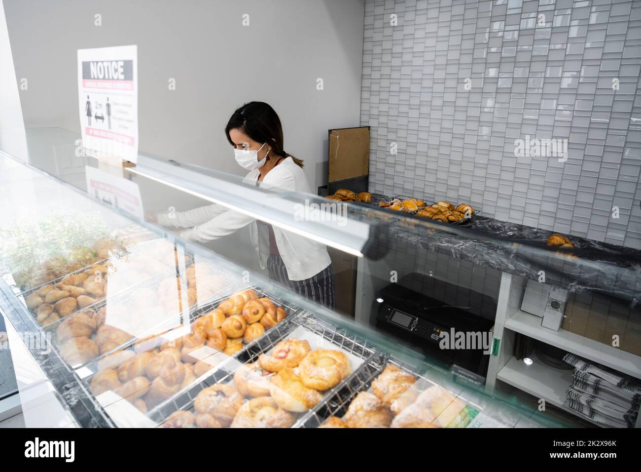 Female bakery owner in face mask at pastry display case Stock Photo - Alamy
