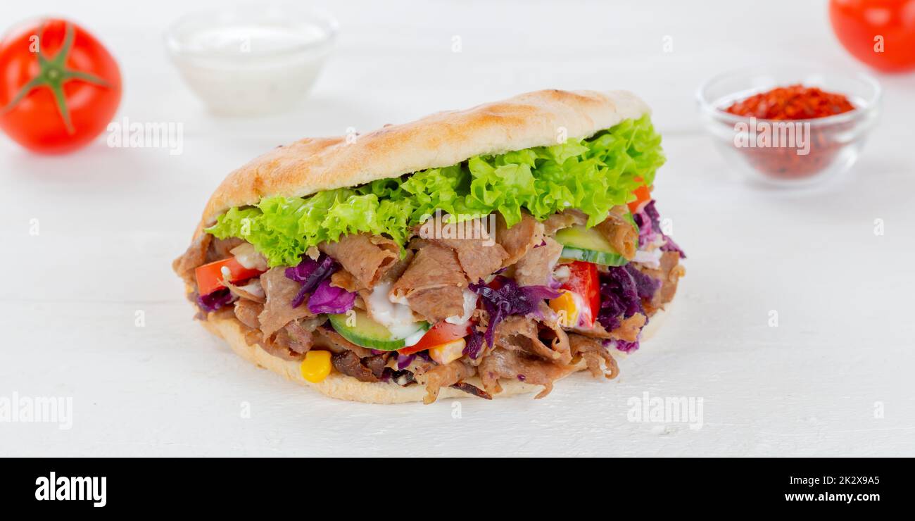 DÃ¶ner Kebab Doner Kebap fast food in flatbread on a wooden board ...
