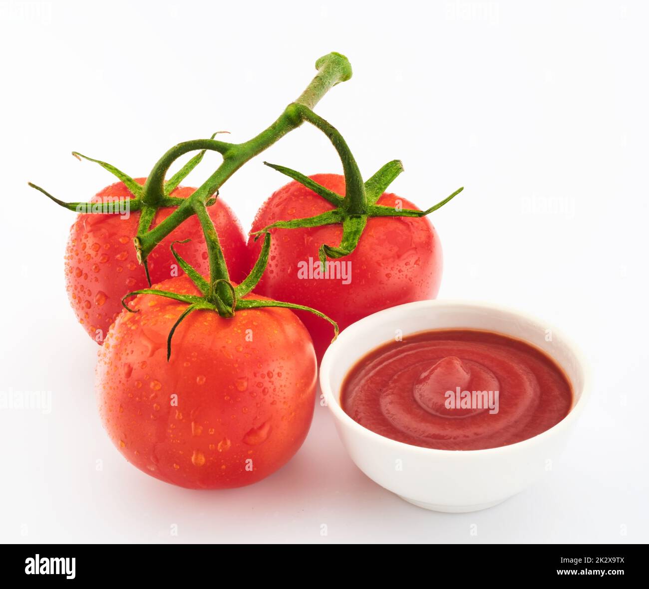 Freshly prepared ketchup with ripe red tomatoes on a white background ...