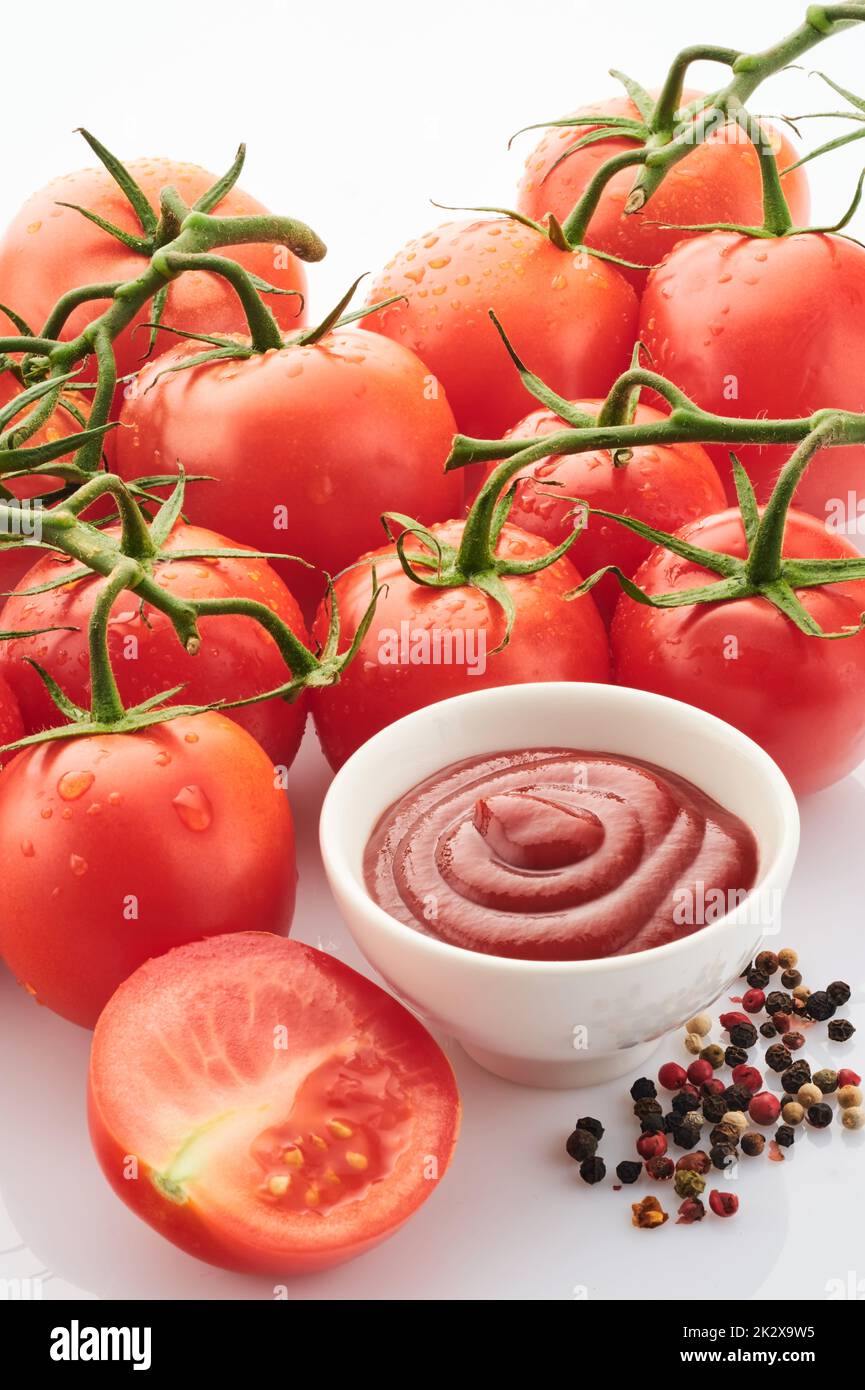 Freshly prepared ketchup with ripe red tomatoes on a white background ...