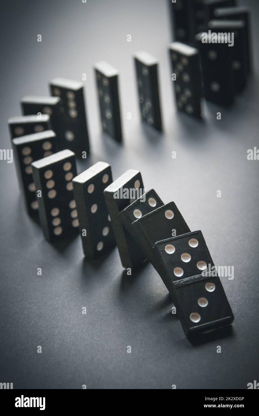 Black dominoes chain on table background Stock Photo - Alamy