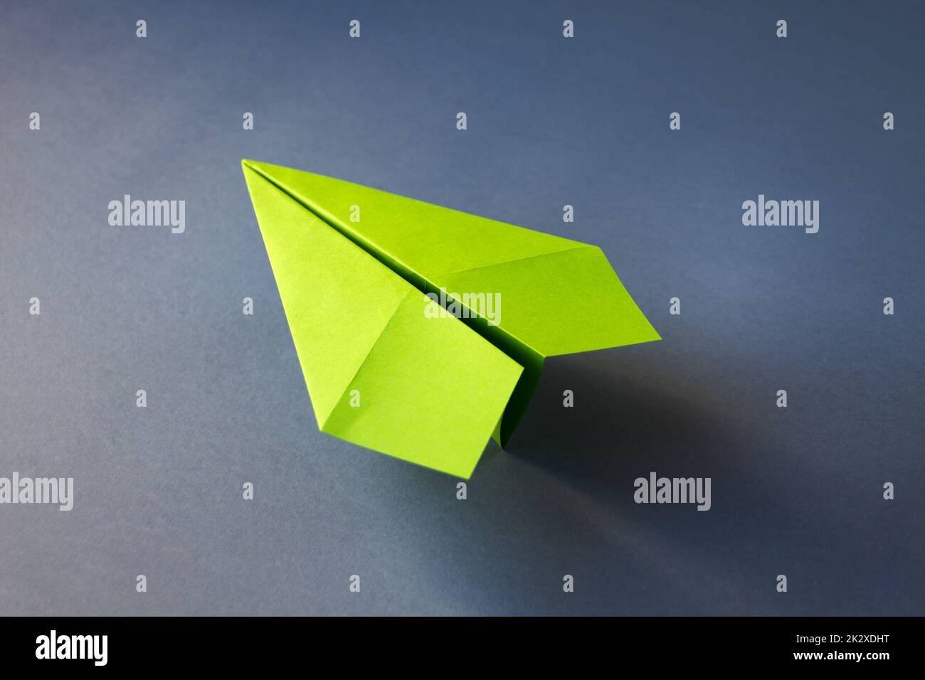 Green paper plane origami isolated on a grey background Stock Photo - Alamy