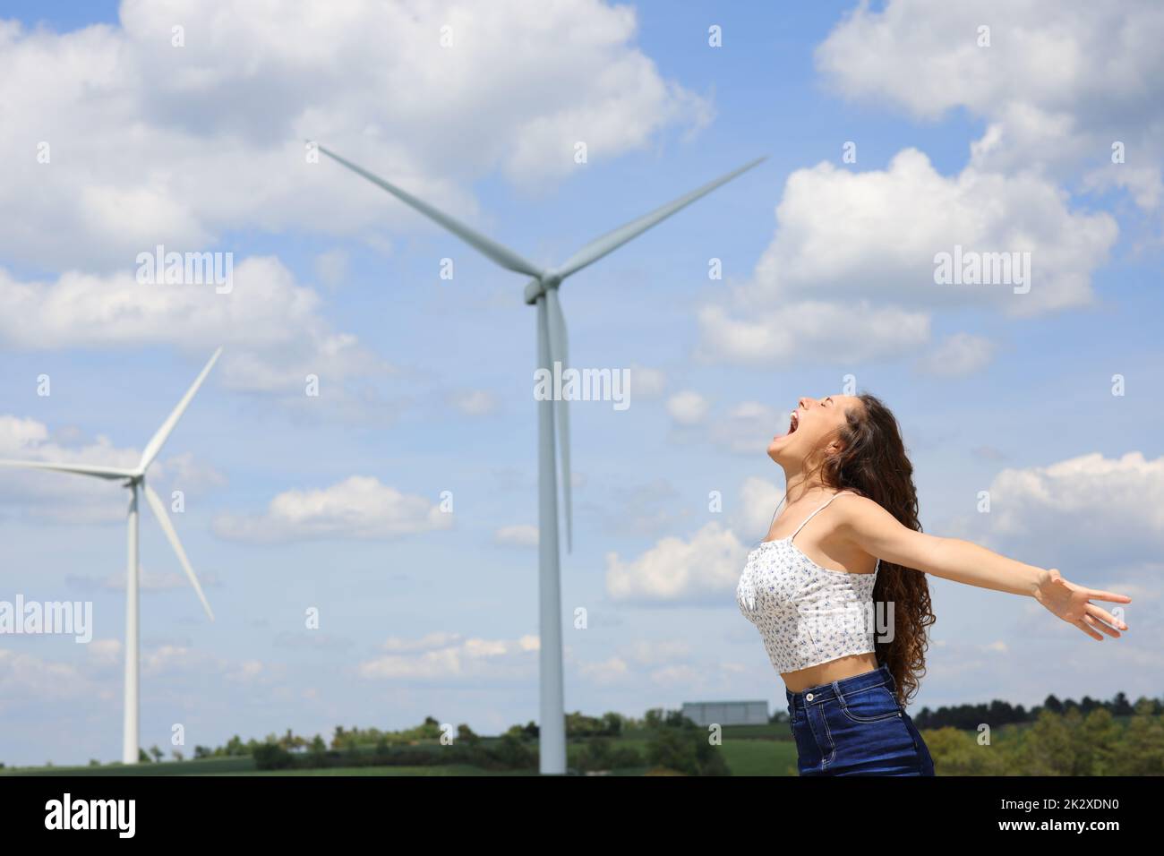 Excited woman screaming in a wind farm Stock Photo - Alamy