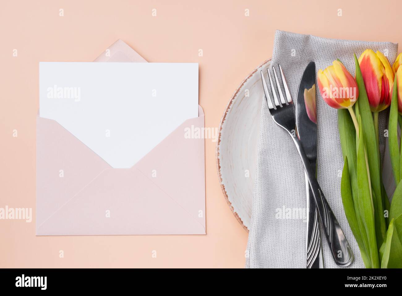 Mockup of a festive invitation in an envelope and a festive table ...