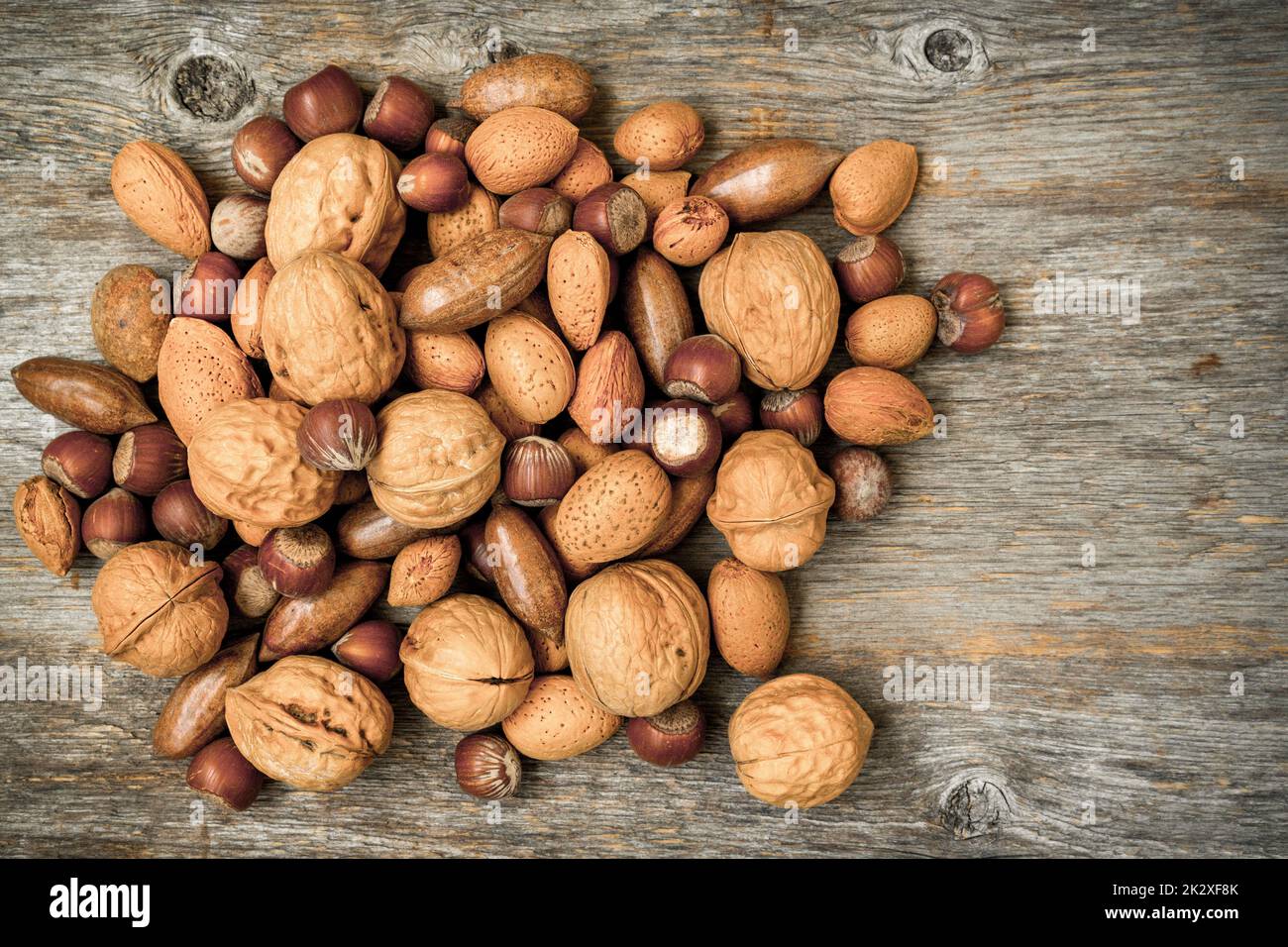 Pile of assorted nuts on wooden background Stock Photo - Alamy