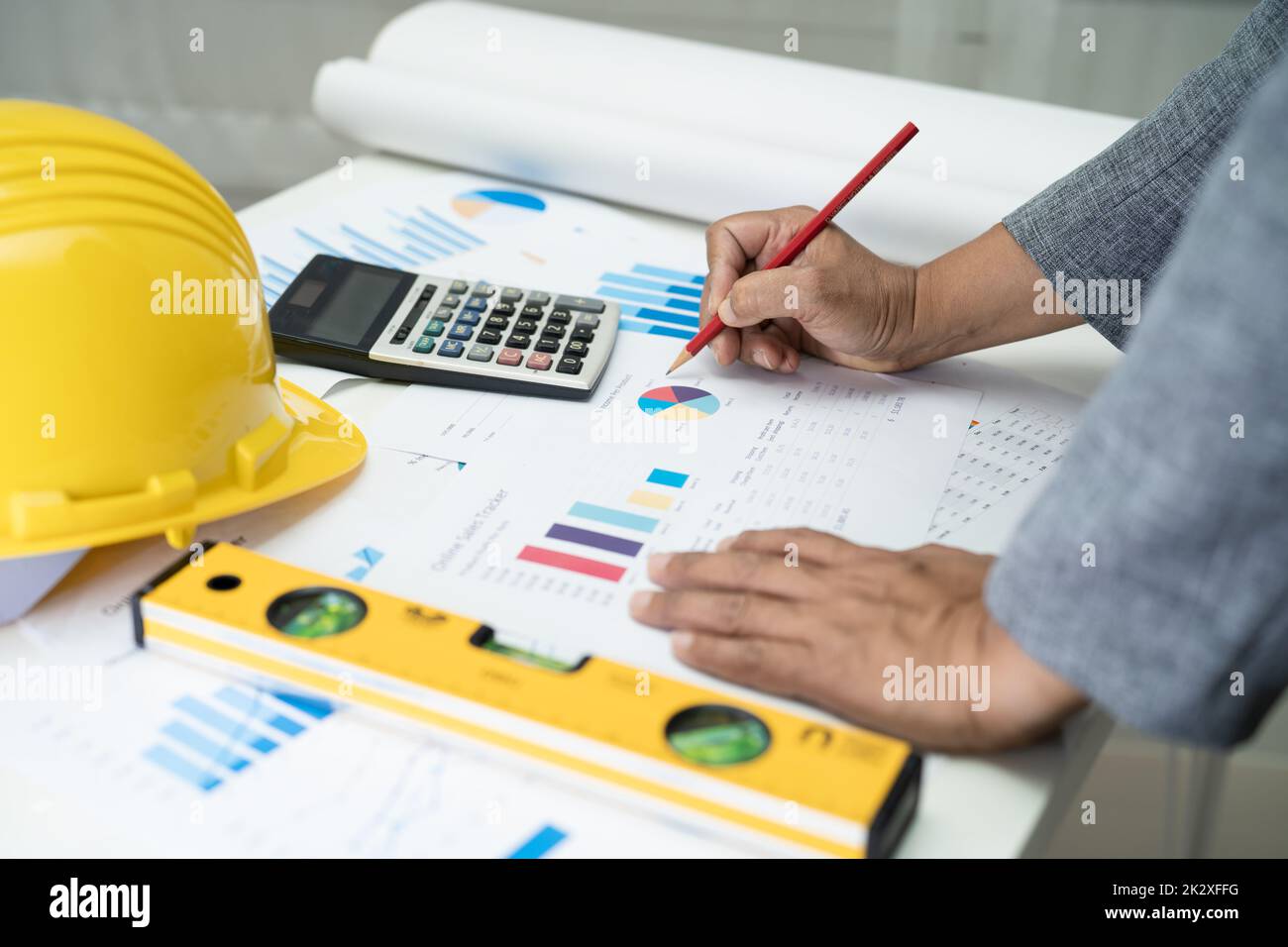 Asian engineer with architectural house plan project blueprint, graph ...