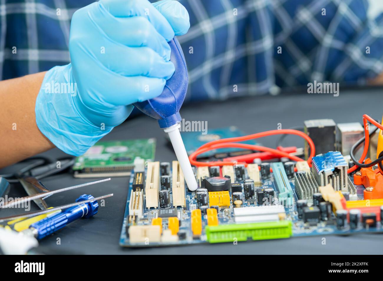 Technician use air blower ball to clean dust in circuit board computer ...