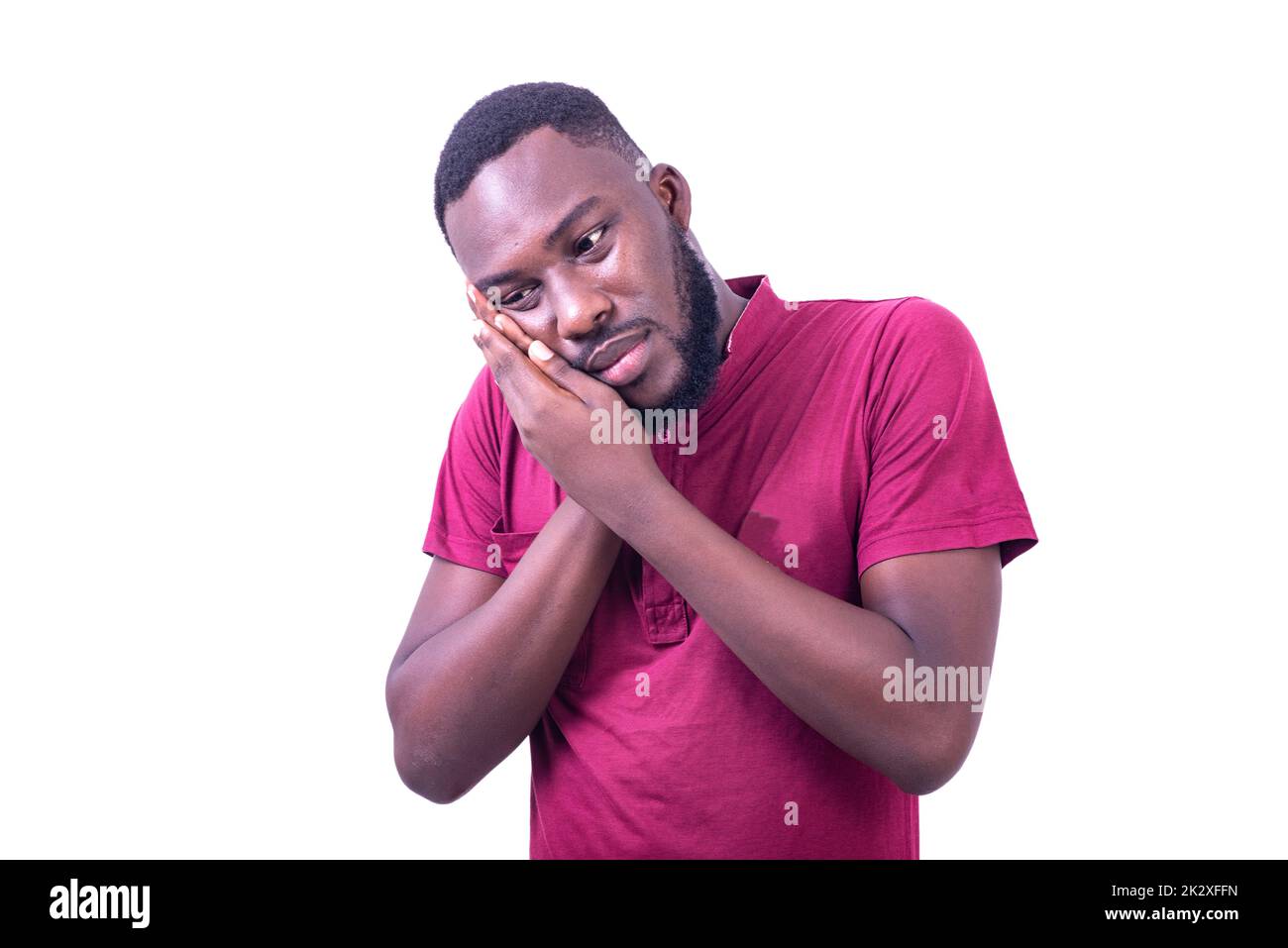 handsome calm young man, wearing red t-shirt, with hands on cheek ...