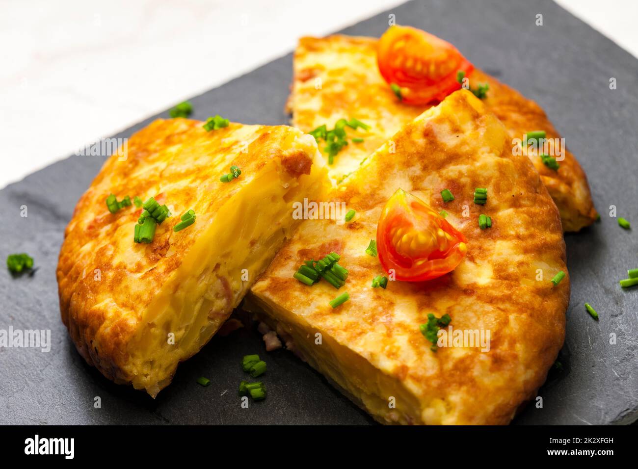 Spanish tortilla with tomatoes and chive Stock Photo - Alamy