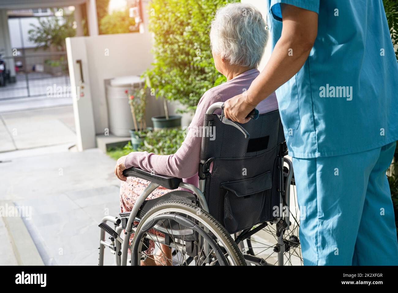 Caregiver help and care Asian senior or elderly old lady woman patient ...