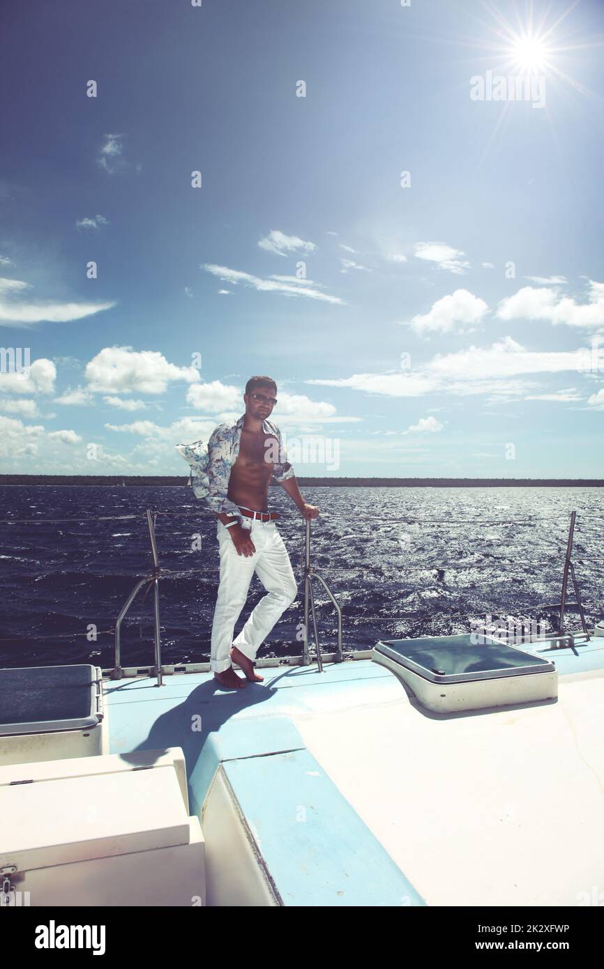 Young man sailing his boat on the open ocean Stock Photo - Alamy
