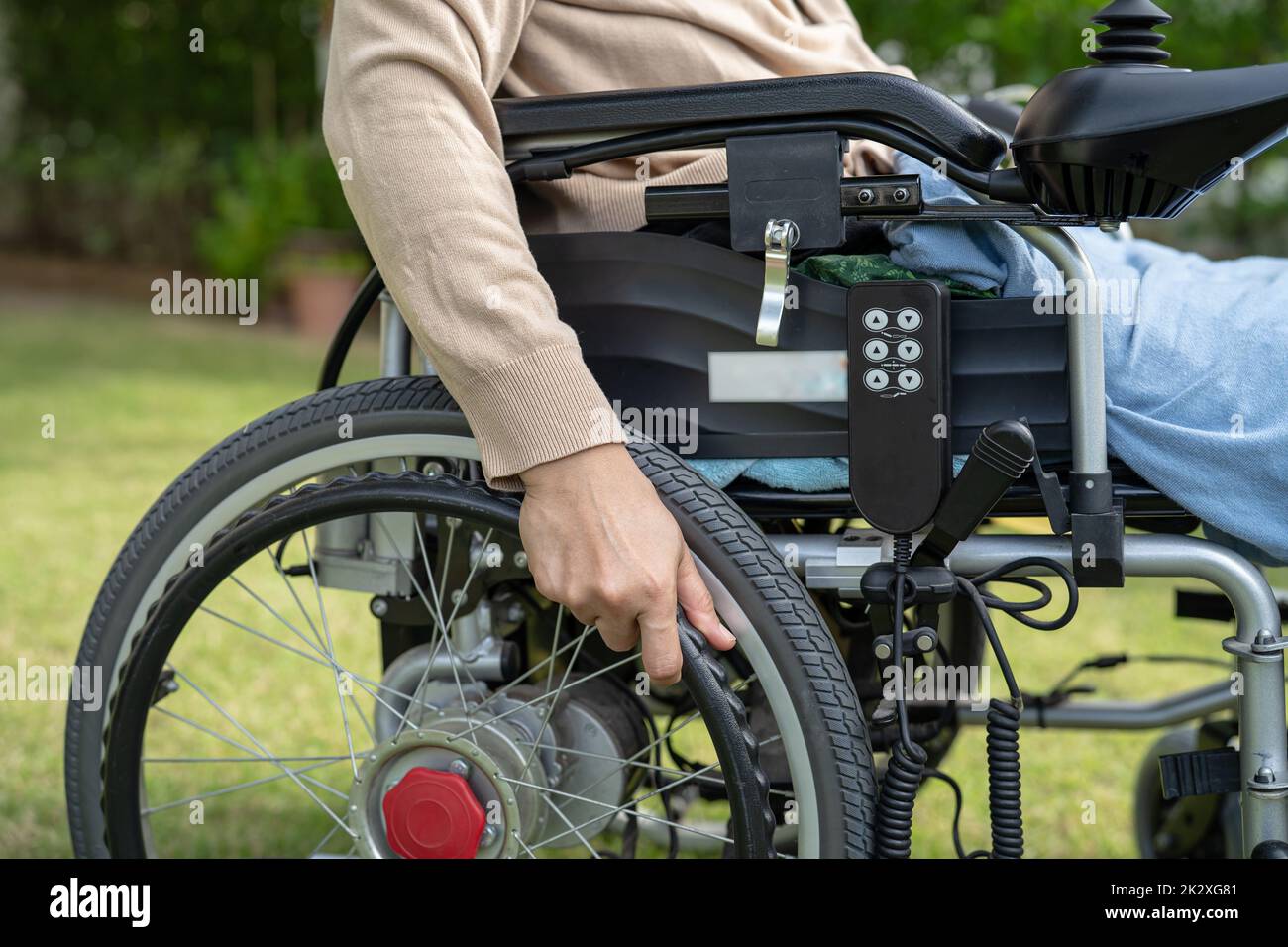 Asian lady woman patient on electric wheelchair with joystick and ...