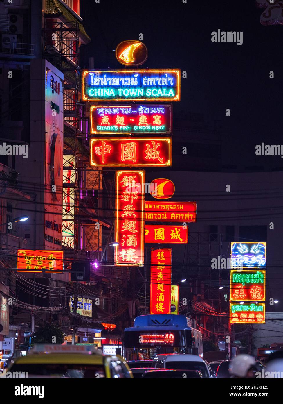 A vertical of red neon signs captured at night in Chinatown, Bangkok next to a street with ...
