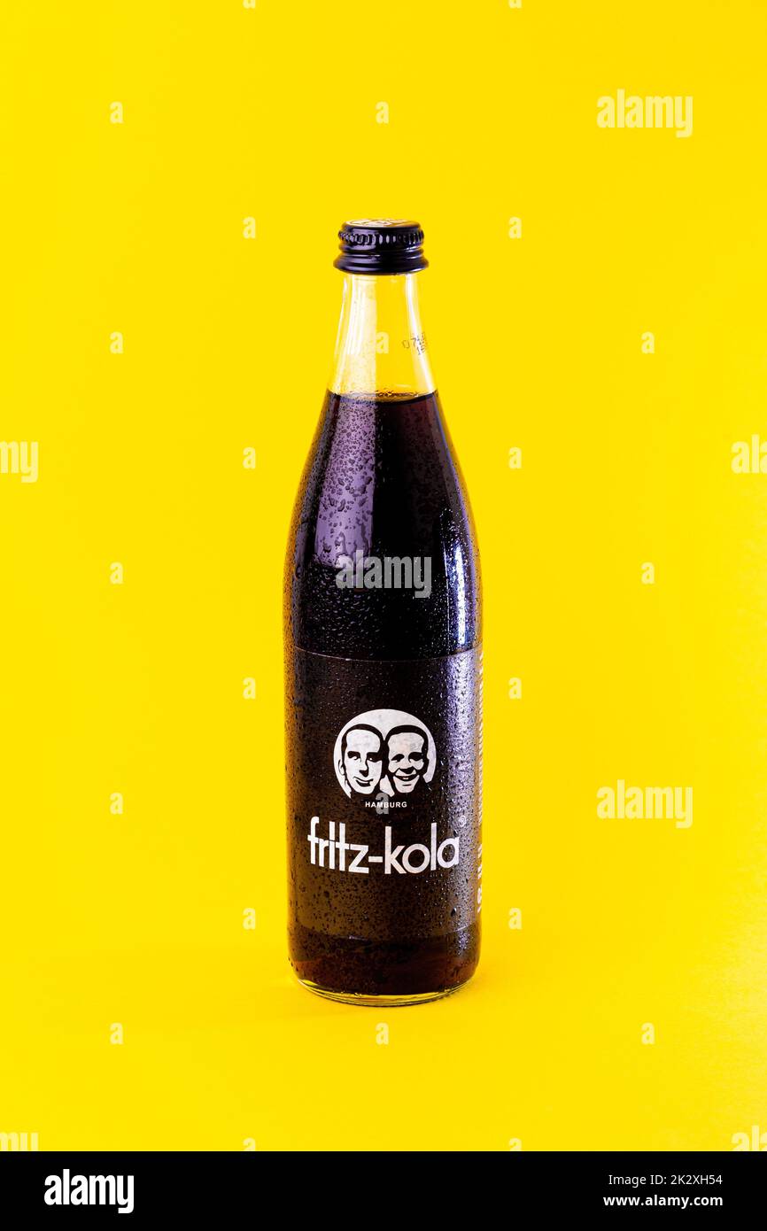 A vertical view of the glass bottle of Fritz Kola drink over the yellow ...