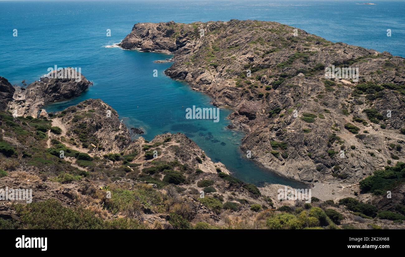 An aerial view of Fredosa cove rocky beach surrounded by emerald water ...