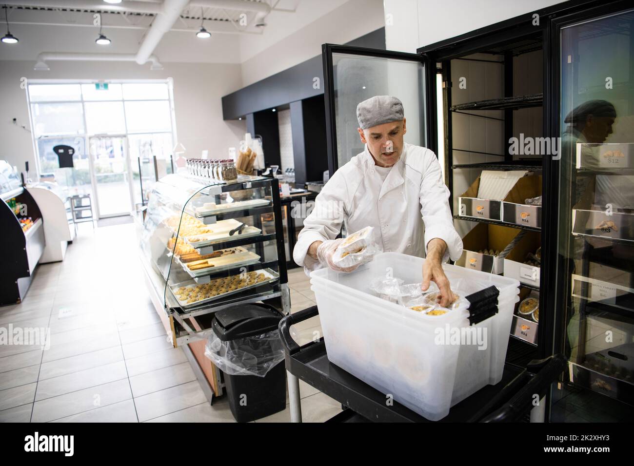 Male baker placing pastries in bin inside bakery Stock Photo - Alamy Male baker placing pastries in bin inside bakery Stock Photo - Alamy