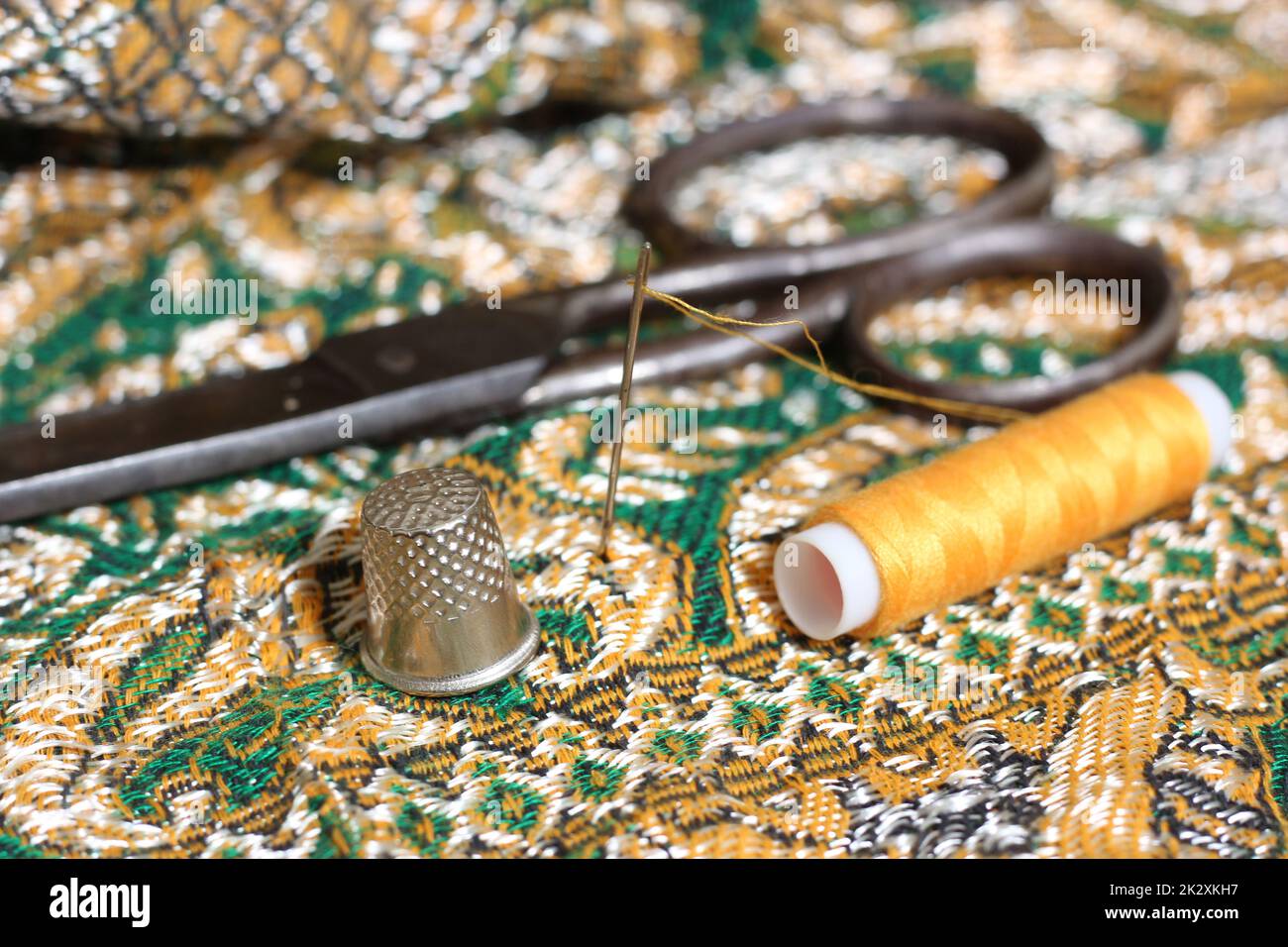 Golden Thread and Thimble on Vintage Fabric From The Middle East Stock ...