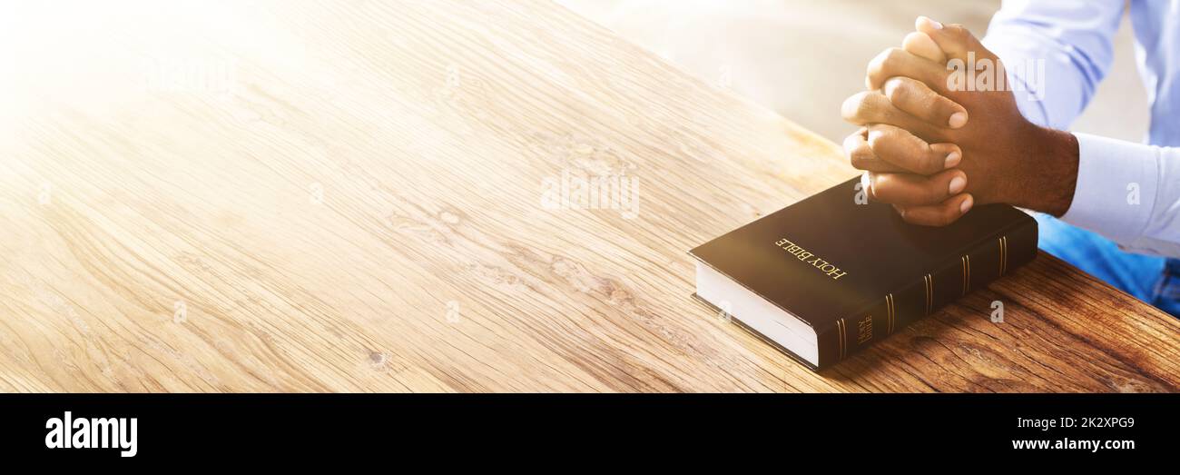 Man's Praying Hands On Bible Book Stock Photo - Alamy