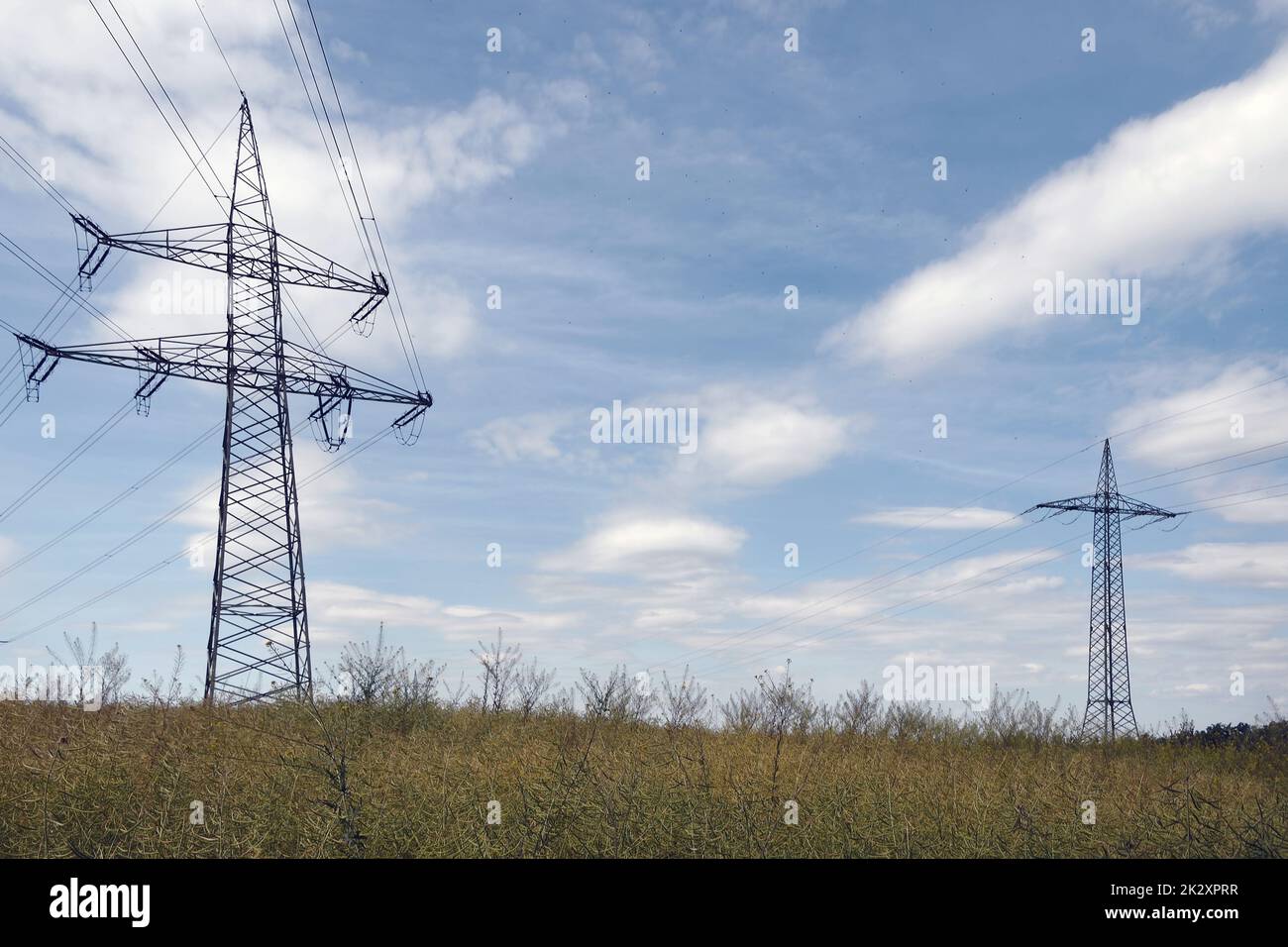 Two Highvoltage pylons and field Stock Photo - Alamy