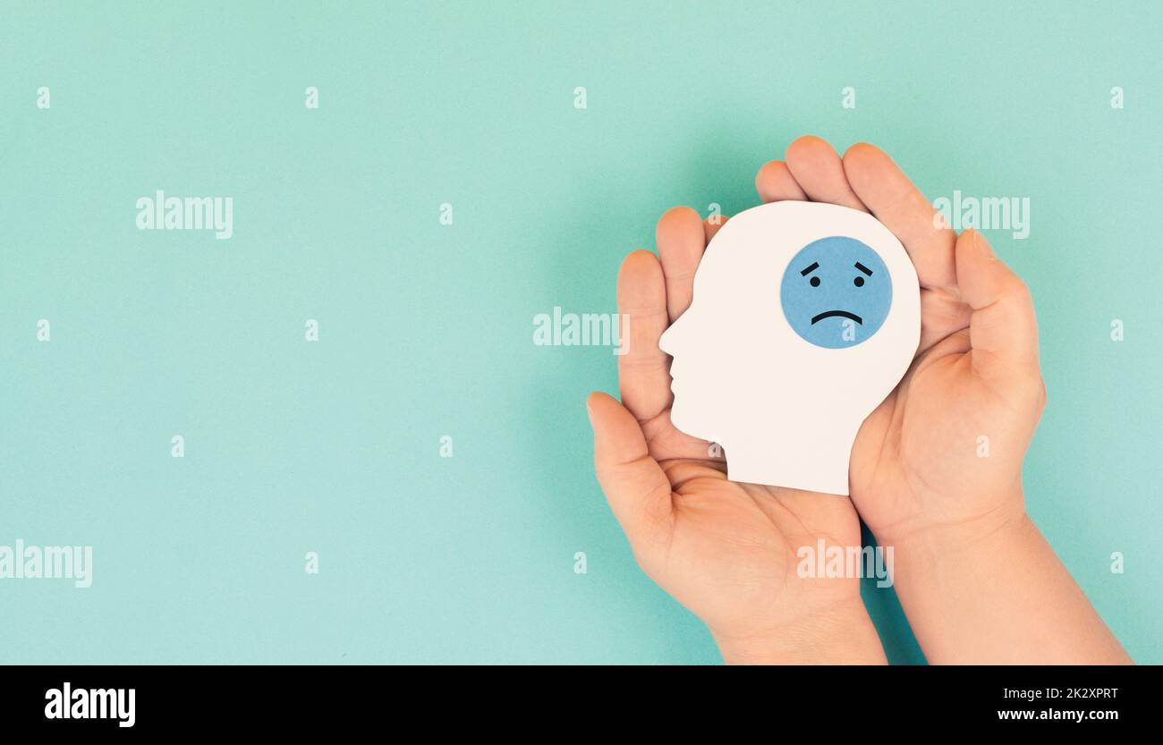 Holding a head with a sad face in the hands, mental health concept ...