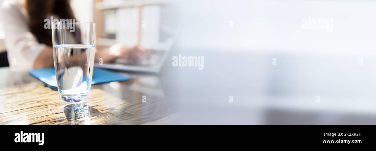 Glass Of Water On Desk Stock Photo - Alamy