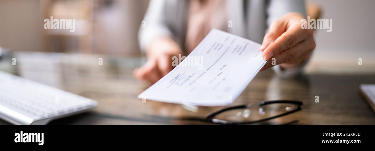 Businessperson's Hand Holding Cheque Stock Photo - Alamy