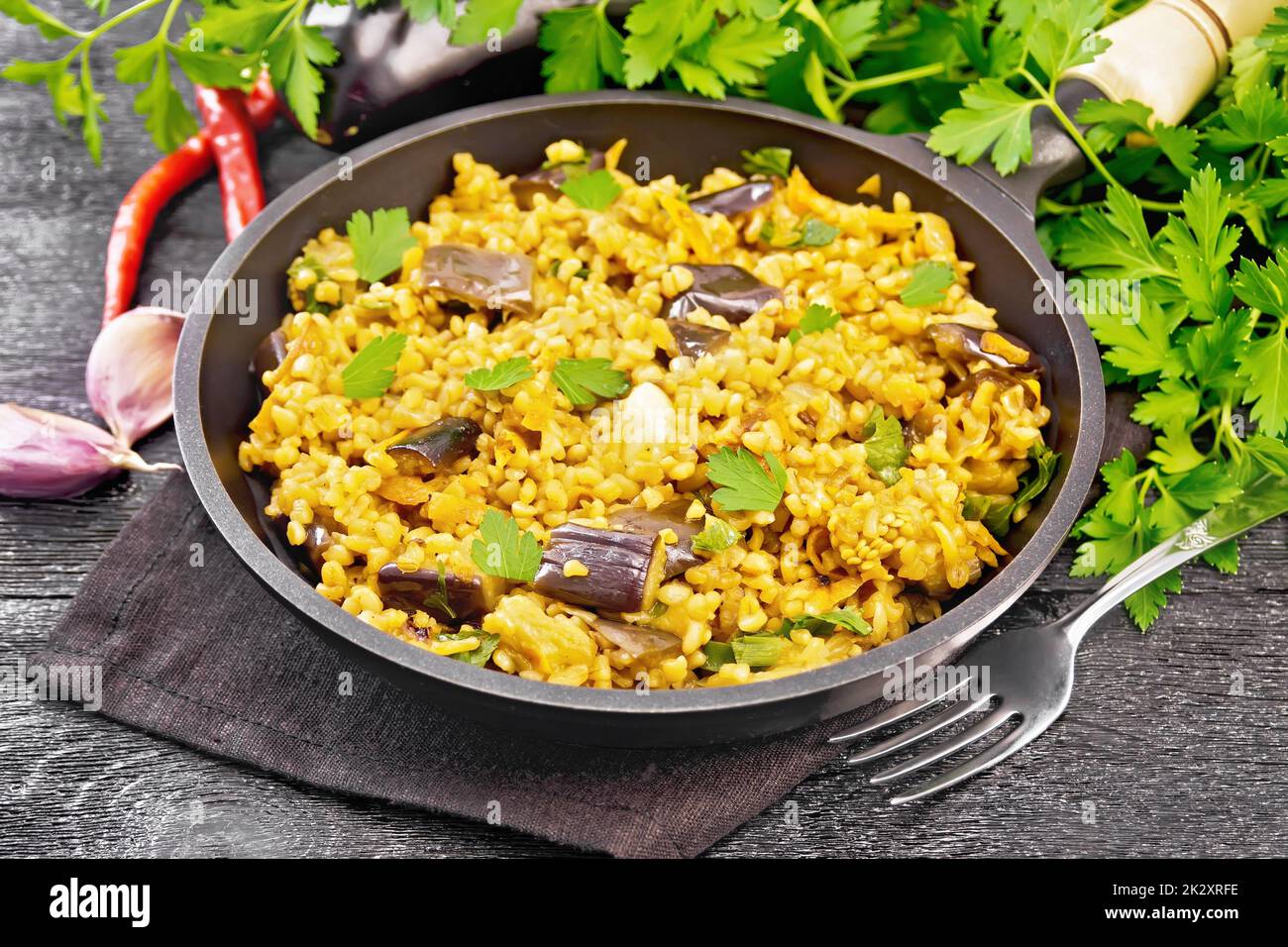 Bulgur with eggplant in pan on dark board Stock Photo - Alamy