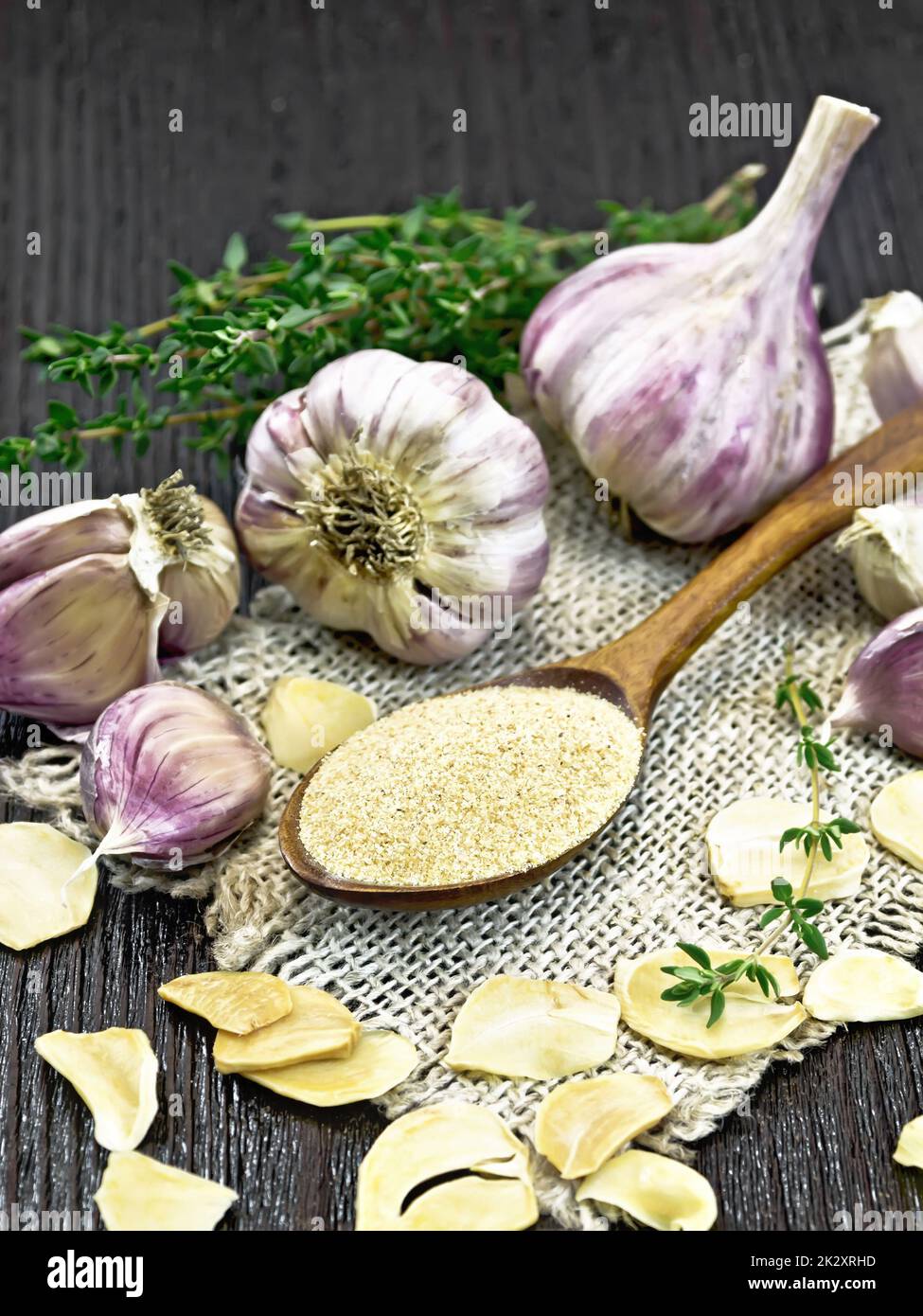 Garlic ground in spoon on dark wooden board Stock Photo - Alamy