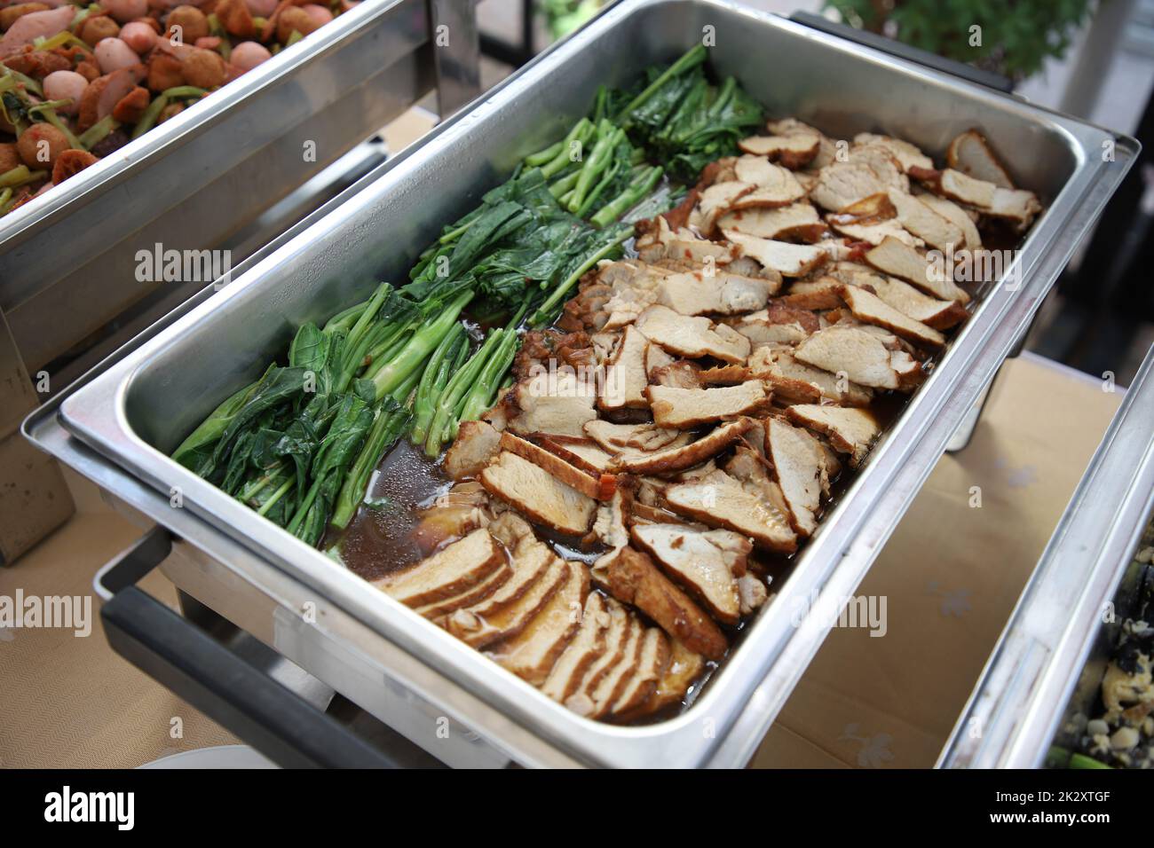 Roast Pork with Vegetables, food in buffet line. The container is a ...