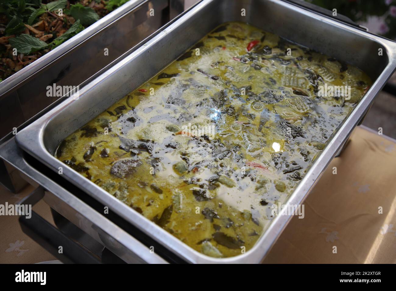 Thai food, Chicken Green Curry in buffet line. The container is a ...