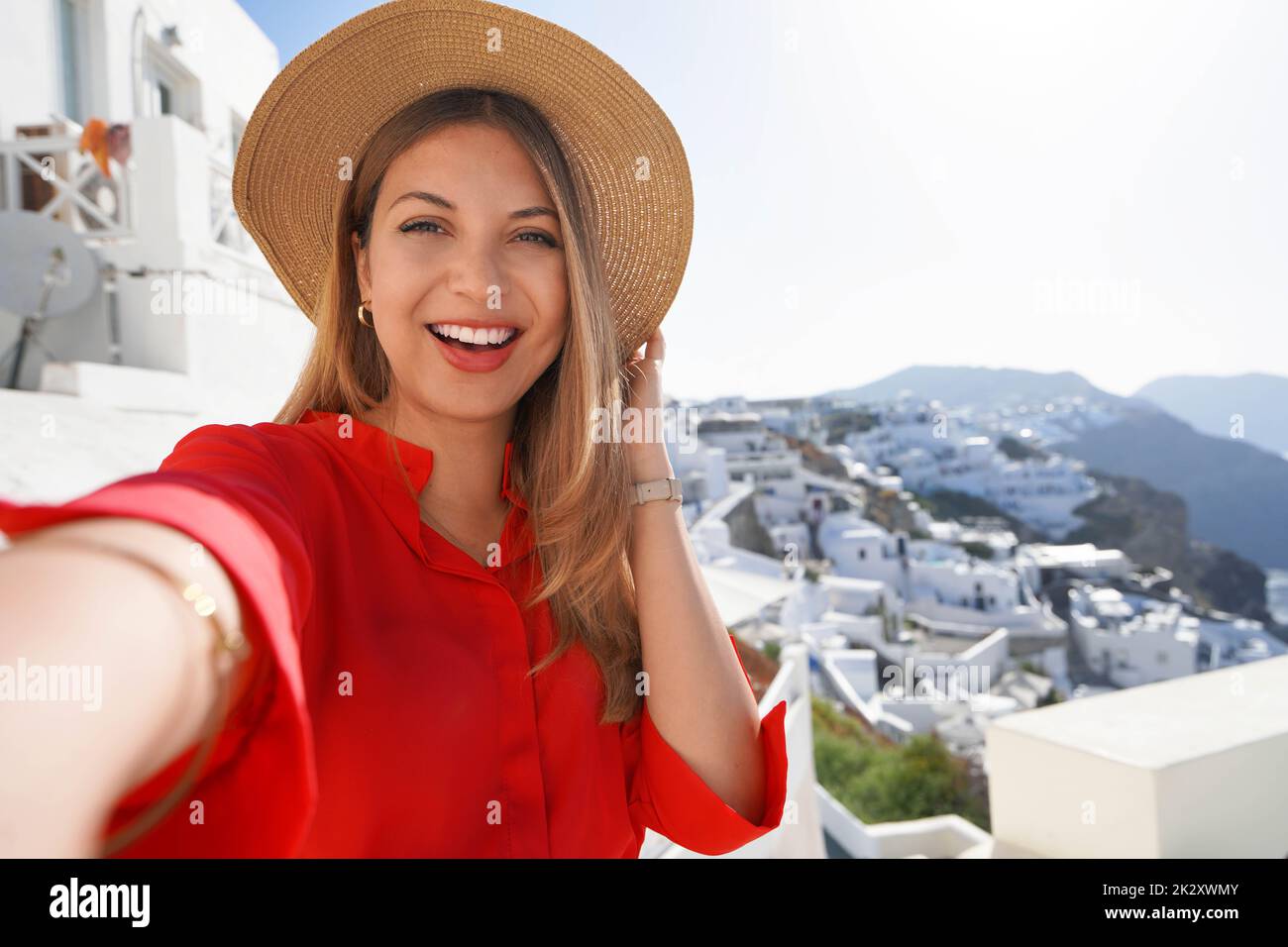 Fashion traveler girl taking selfie photo in Oia picturesque greek ...