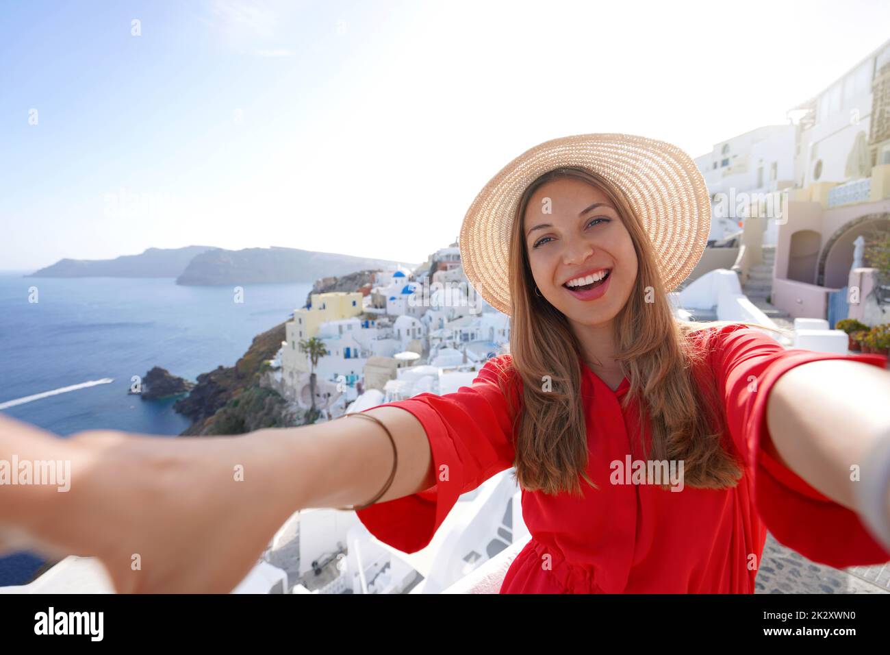Traveler girl taking selfie photo in Santorini on sunset. Smiling woman ...