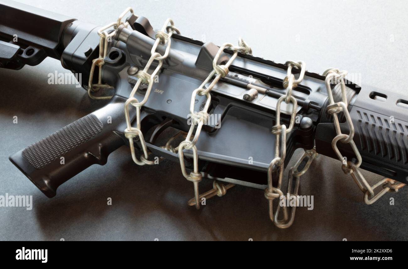 Assault rifle with metal chain keeping it locked up Stock Photo - Alamy