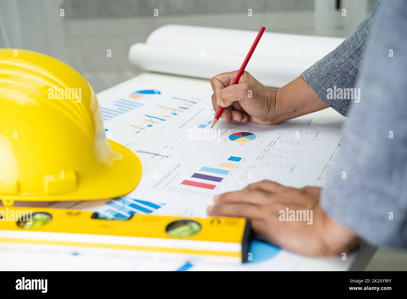 Asian engineer with architectural house plan project blueprint, graph ...