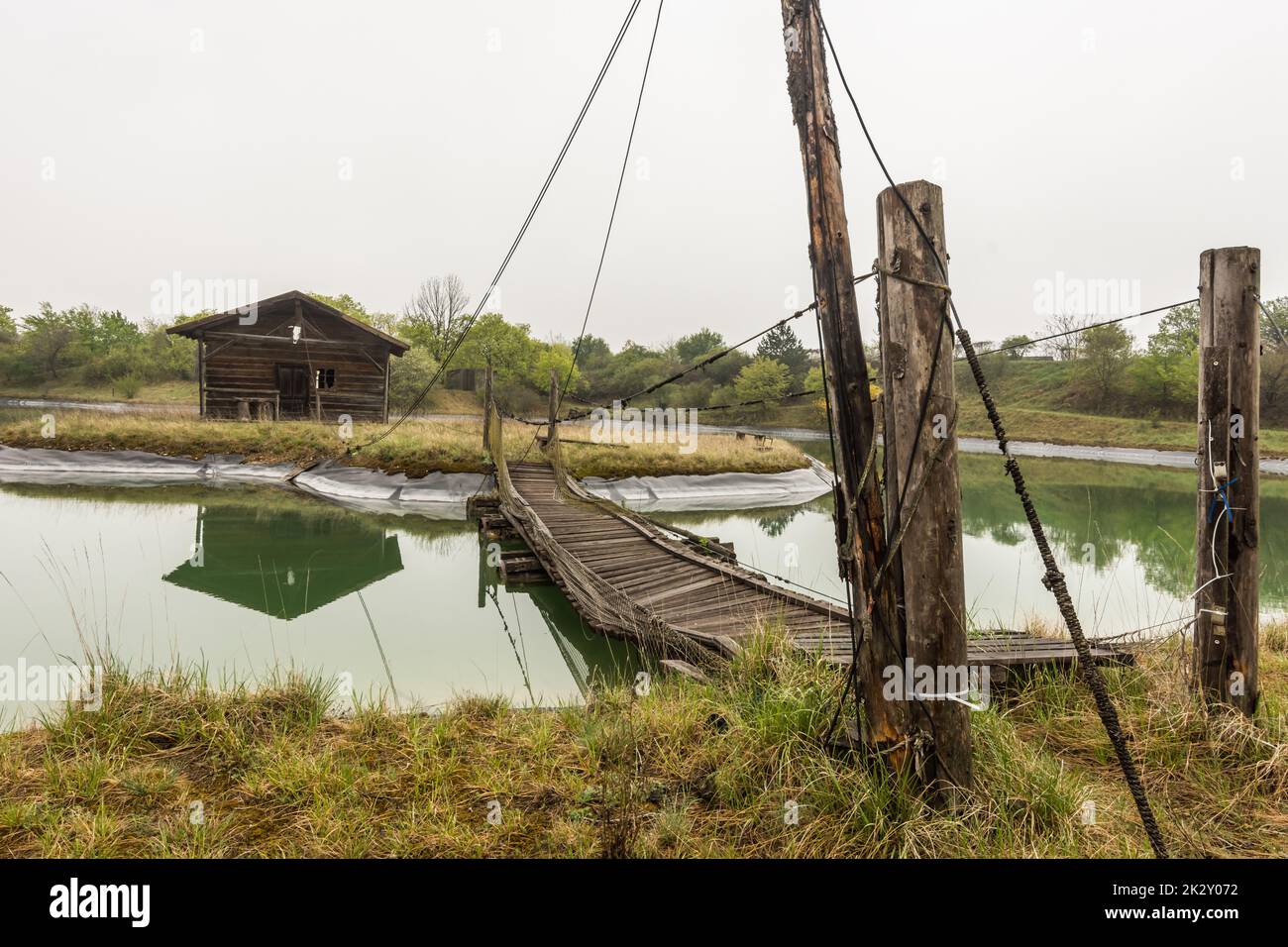 wooden dilapidated bridge to a house on a little island Stock Photo - Alamy