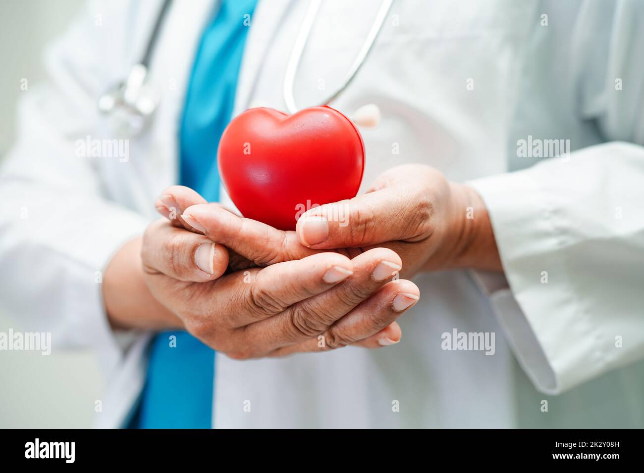 Asian woman doctor holding red heart for health in hospital Stock Photo ...