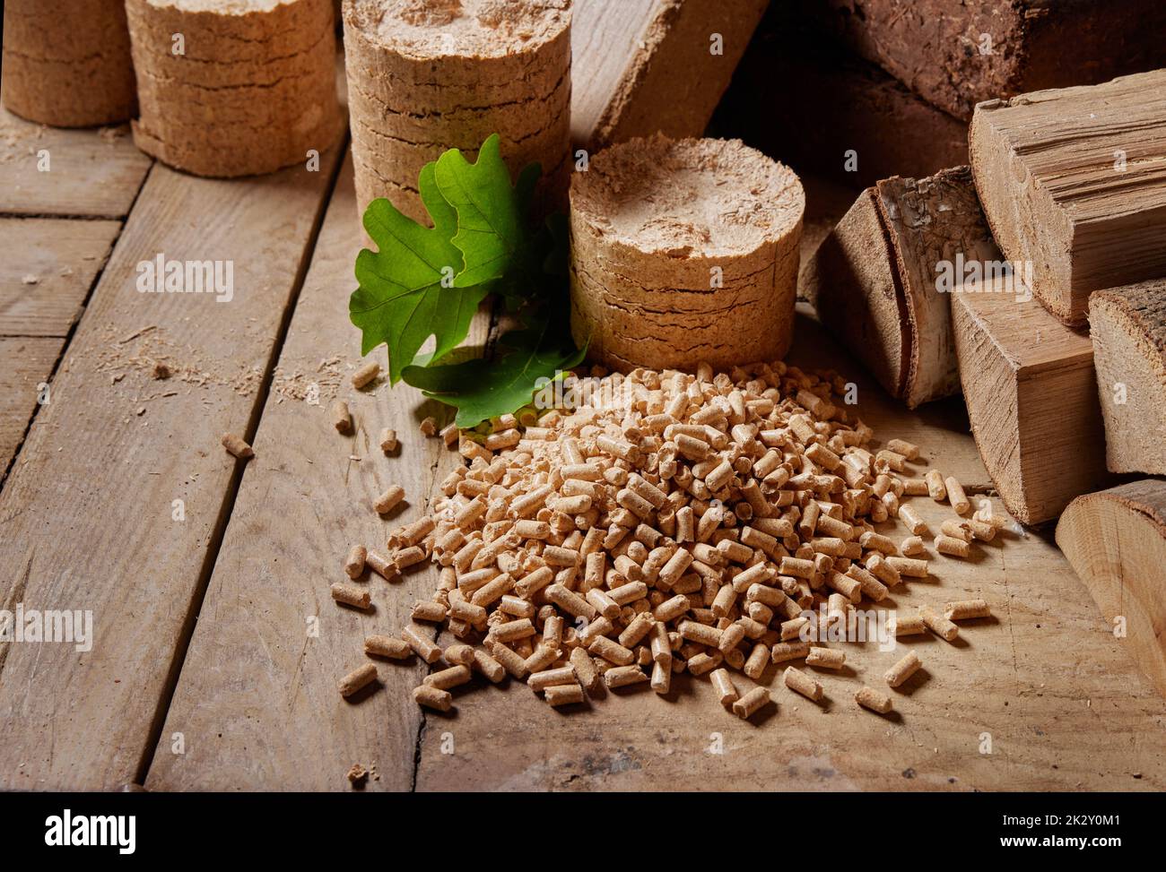Firewood with biofuel briquettes and pellets on timber table Stock ...