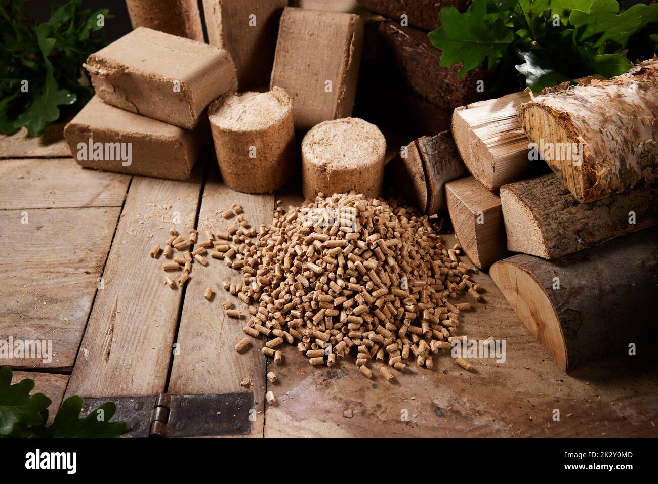 Woodpile and biomass blocks with pellets on timber table Stock Photo ...