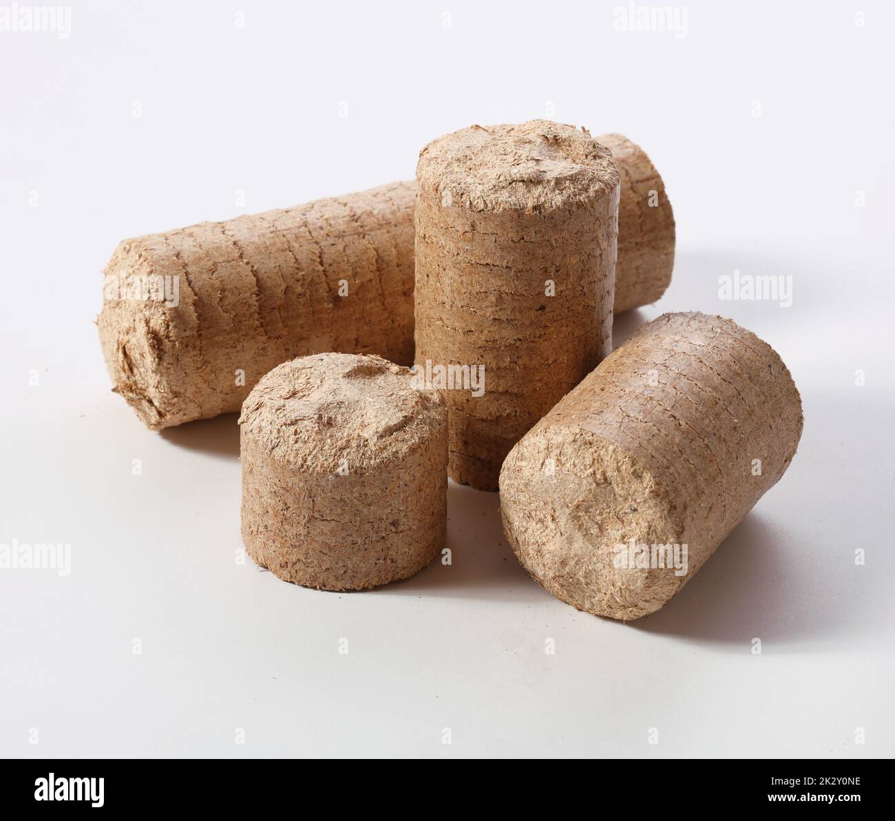Brown compressed biomass briquettes scatted against white background ...
