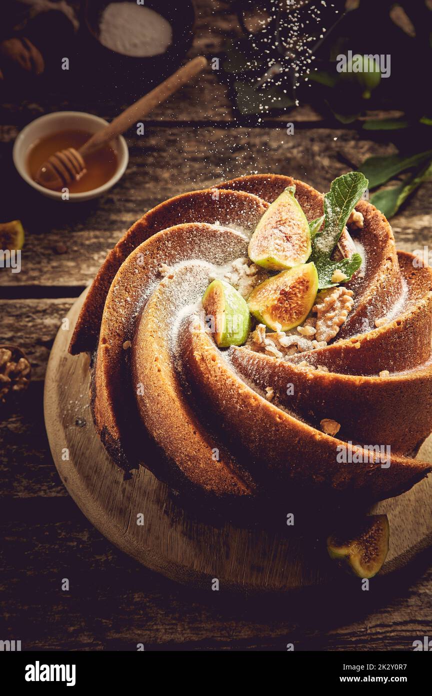 Powdered sugar sprinkling on fig cake Stock Photo - Alamy