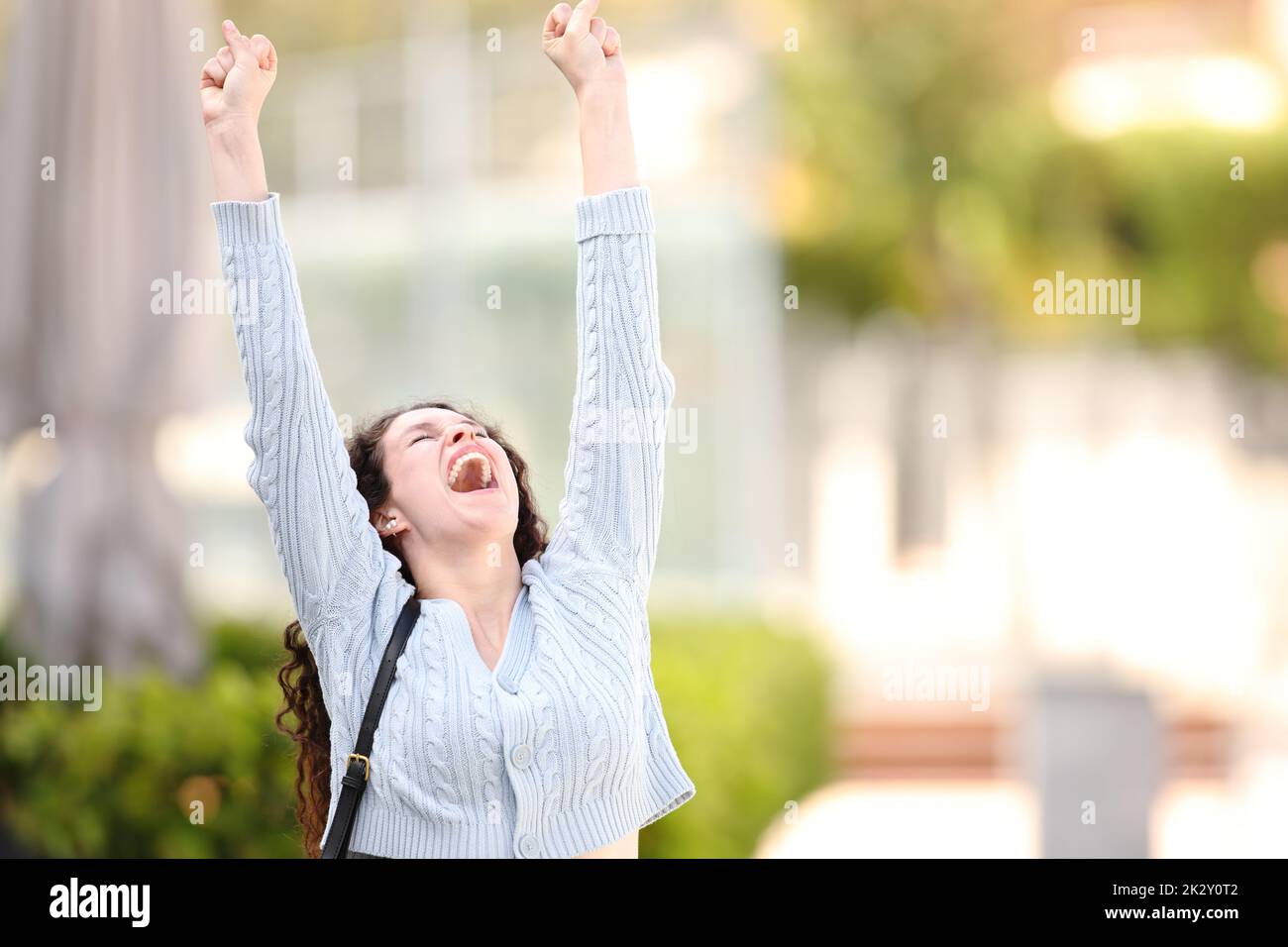 Excited woman raising arms celebrating in the street Stock Photo - Alamy