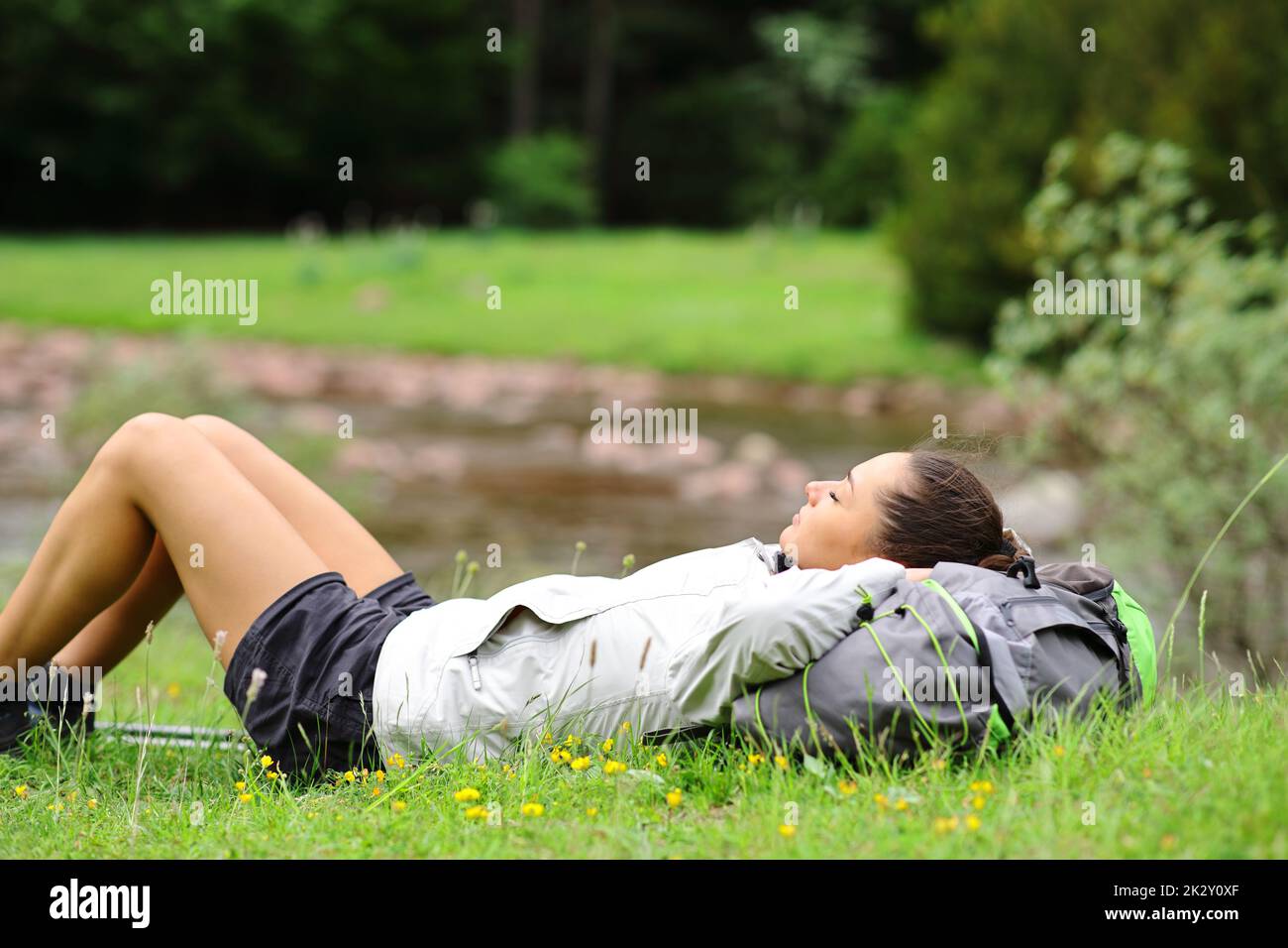 Hiker resting in a riverside lying on the grass Stock Photo - Alamy