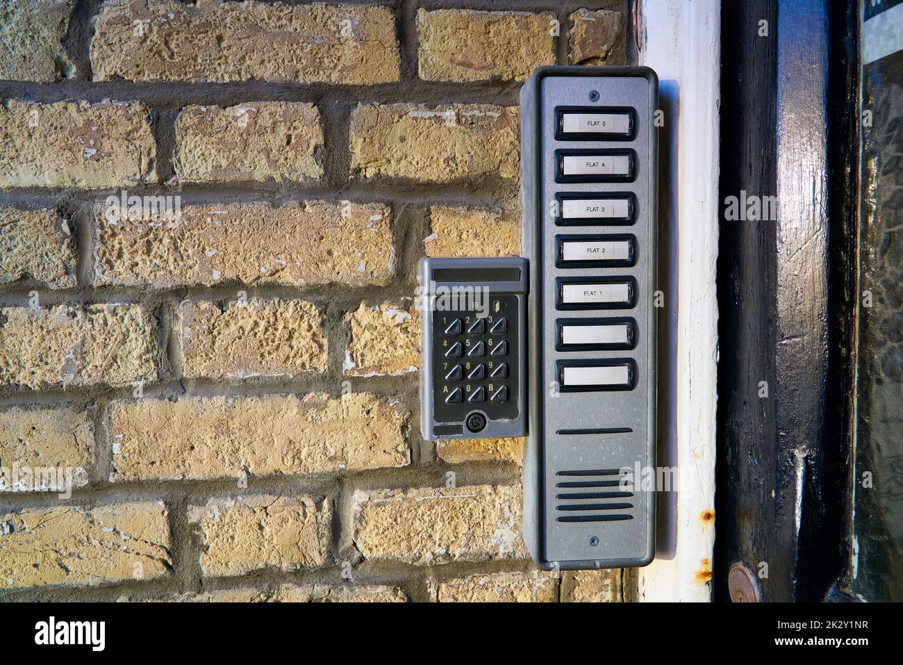 A door entry system and buzzers for each flat on a brick wall Stock ...