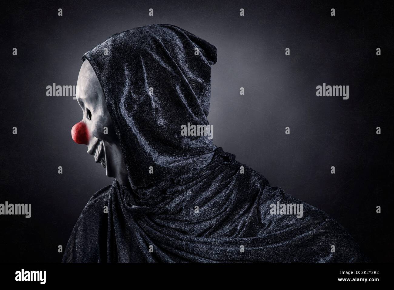 Scary clown showing his teeth over dark misty background Stock Photo ...