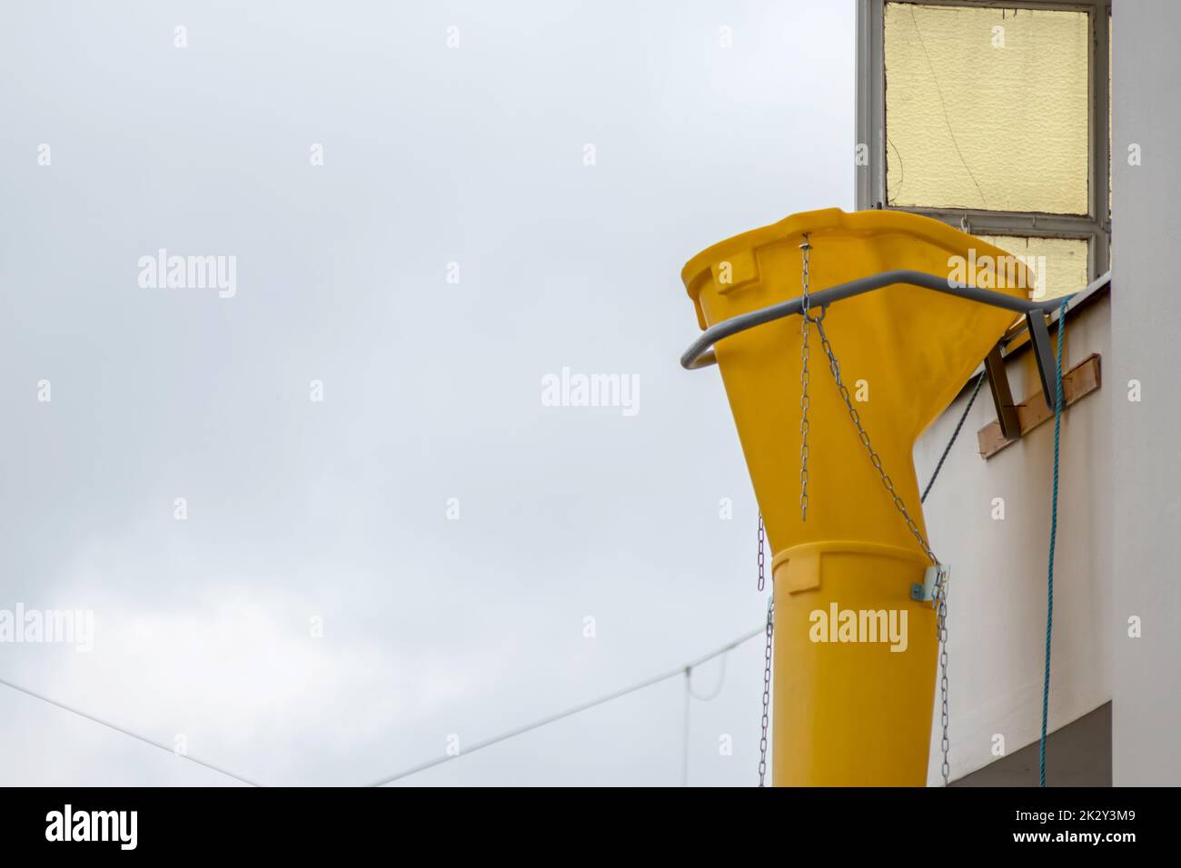 Yellow rubble chute or rubble slide at facade of old white house helps ...
