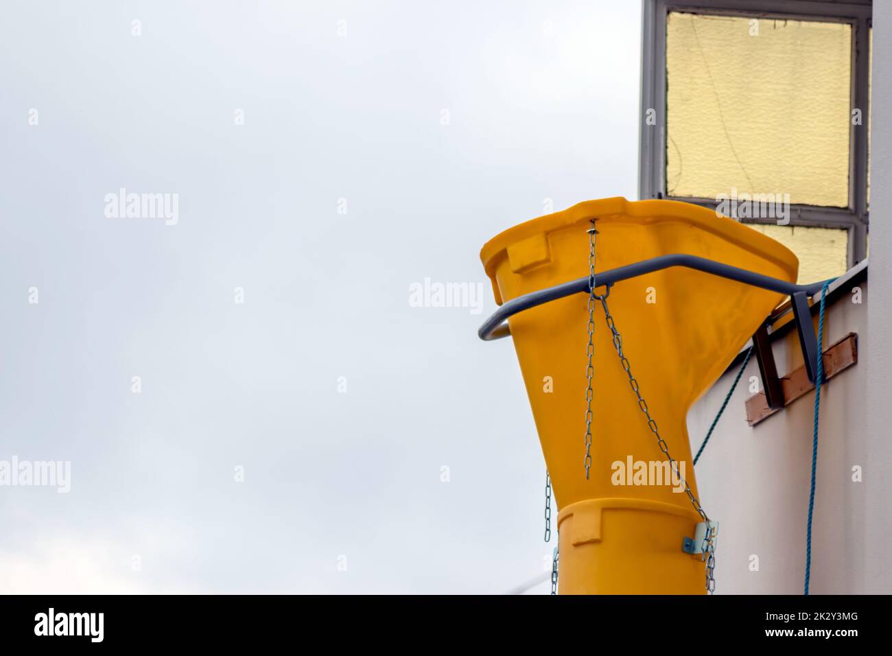 Yellow rubble chute or rubble slide at facade of old white house helps ...